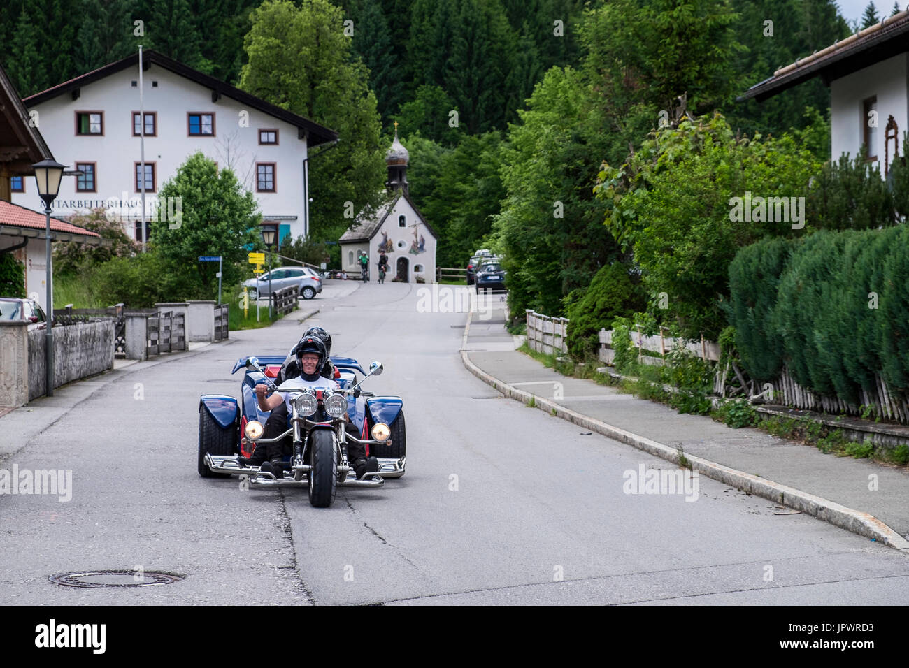 Trike driving through Klais near Mittenwald, Bavaria, Germany Stock ...