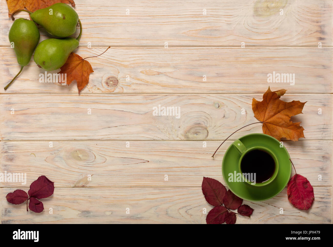 Fall concept. Cups of coffee, pears and autumn leaves on a light wooden ...
