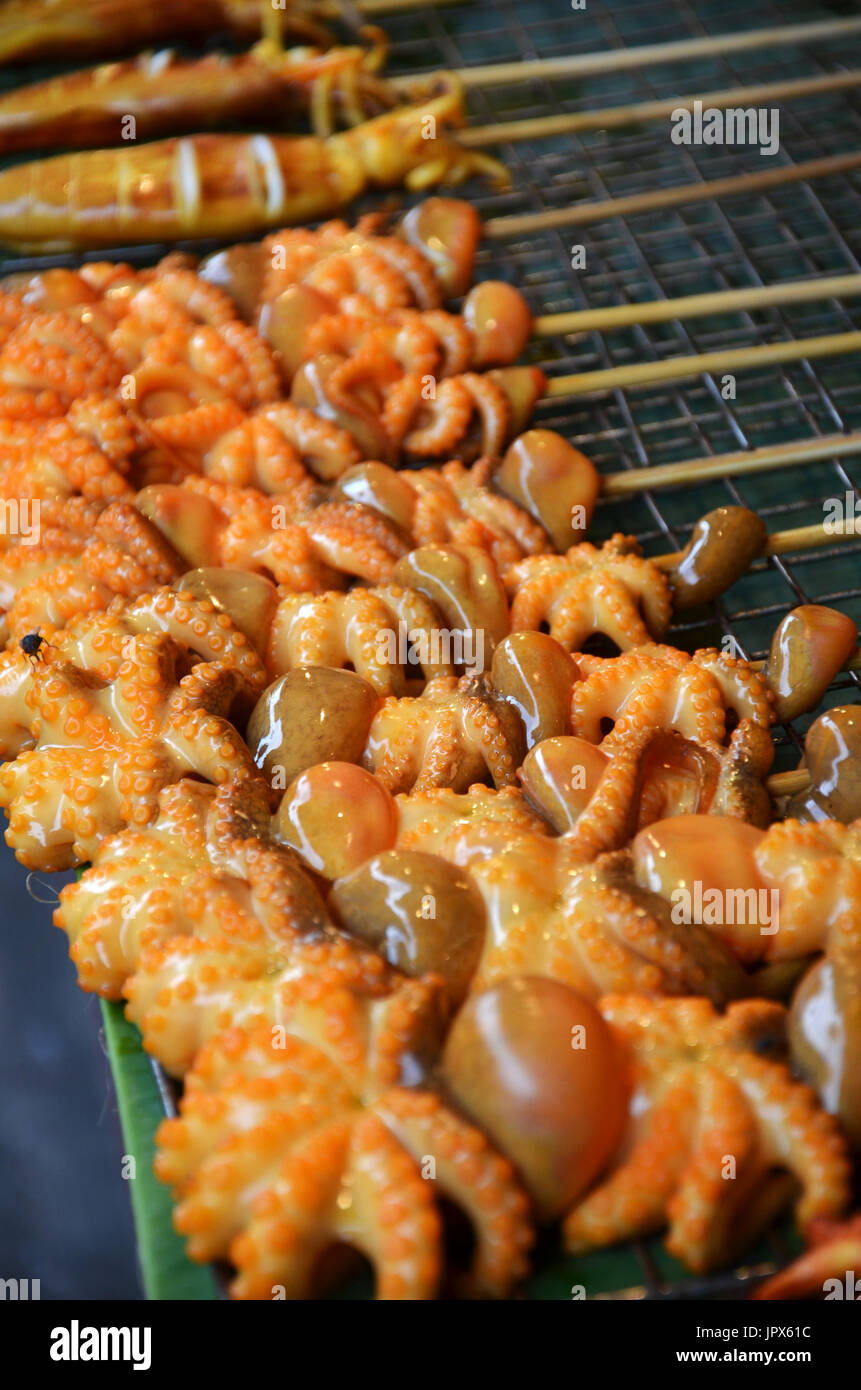 Grilled squid on grid iron in evening street market Stock Photo - Alamy