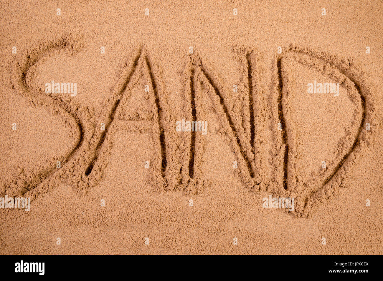 Sand written in soft wet sand on a beach Stock Photo - Alamy