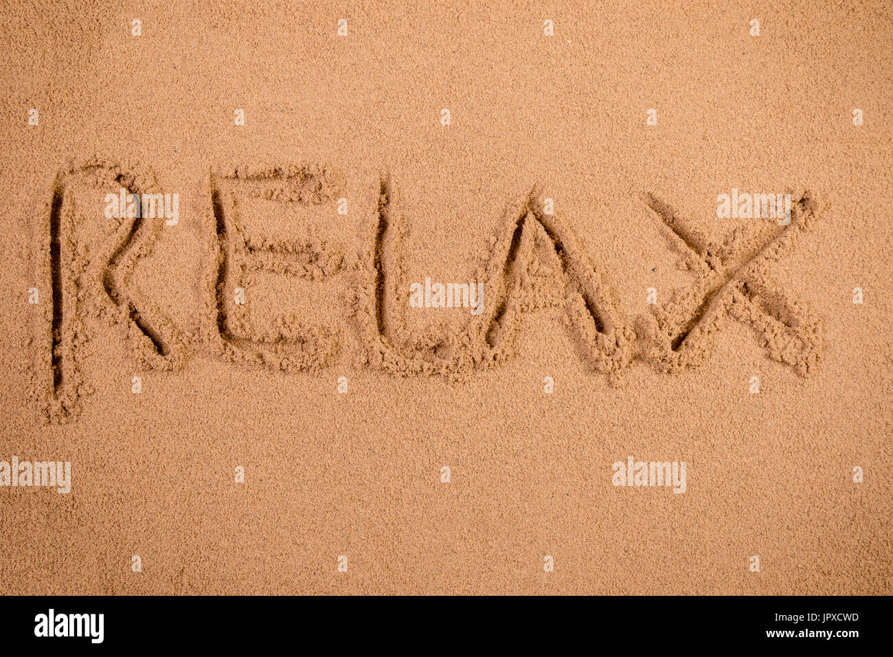 Relax written in soft wet sand on a beach Stock Photo - Alamy