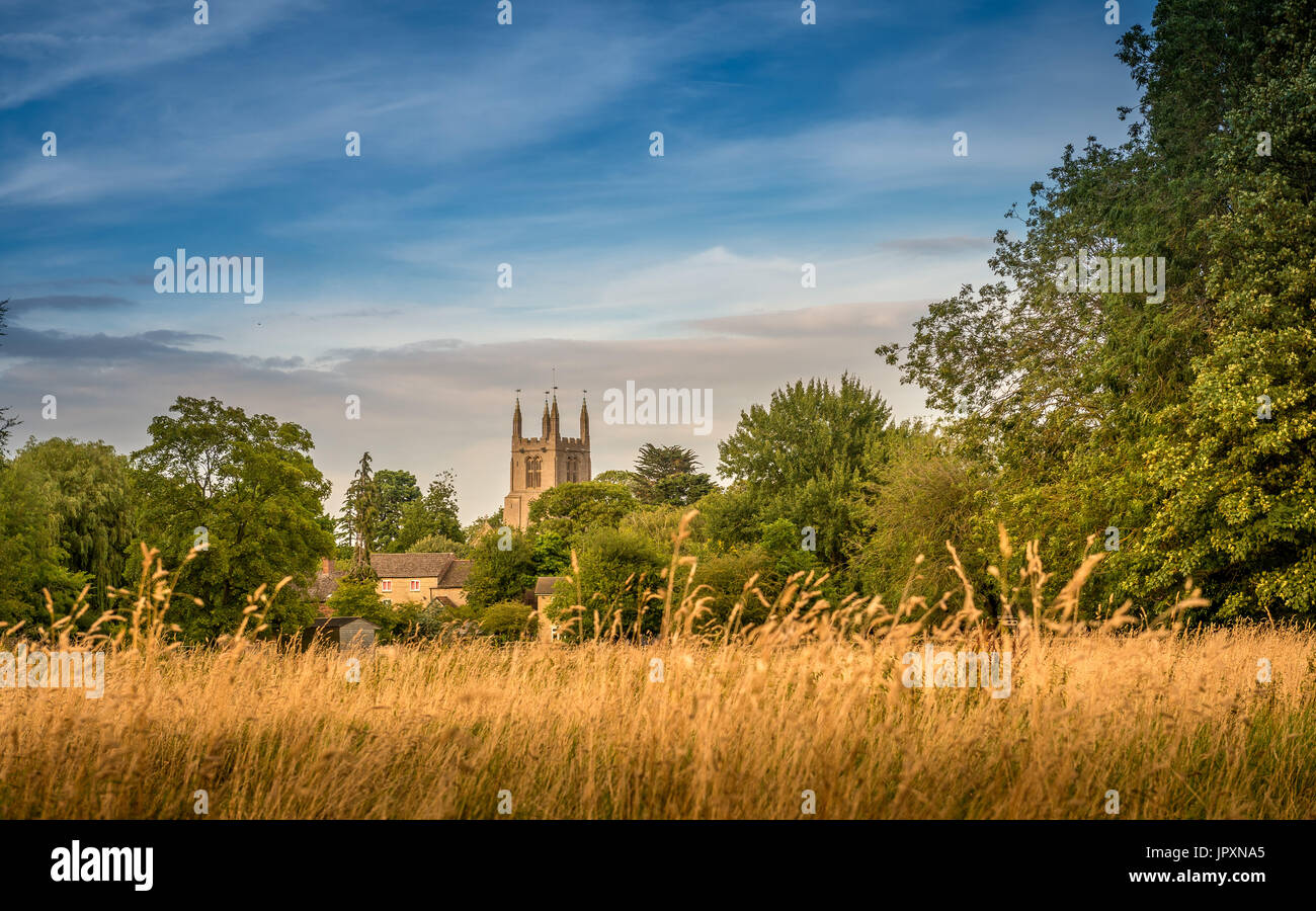 The tower of Abbey church can be seen above the trees and meadows that ...