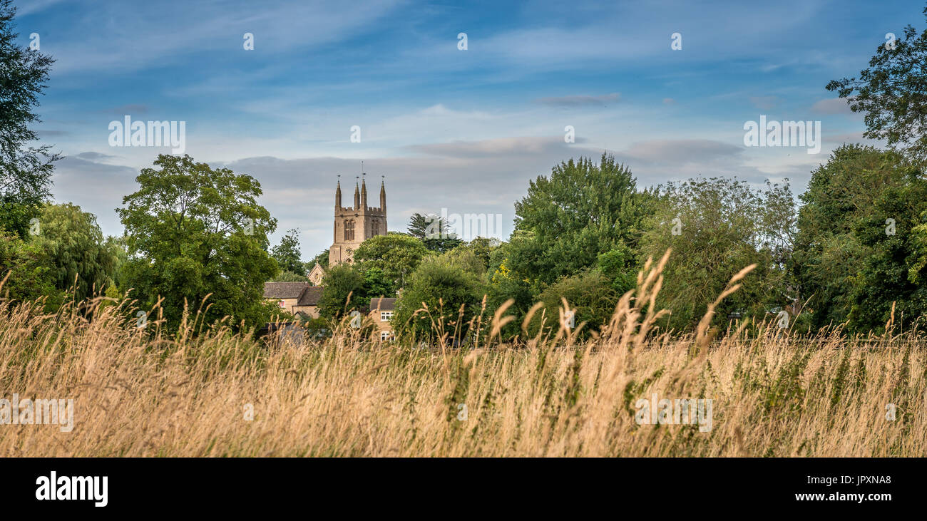 The tower of Abbey church can be seen above the trees and meadows that ...