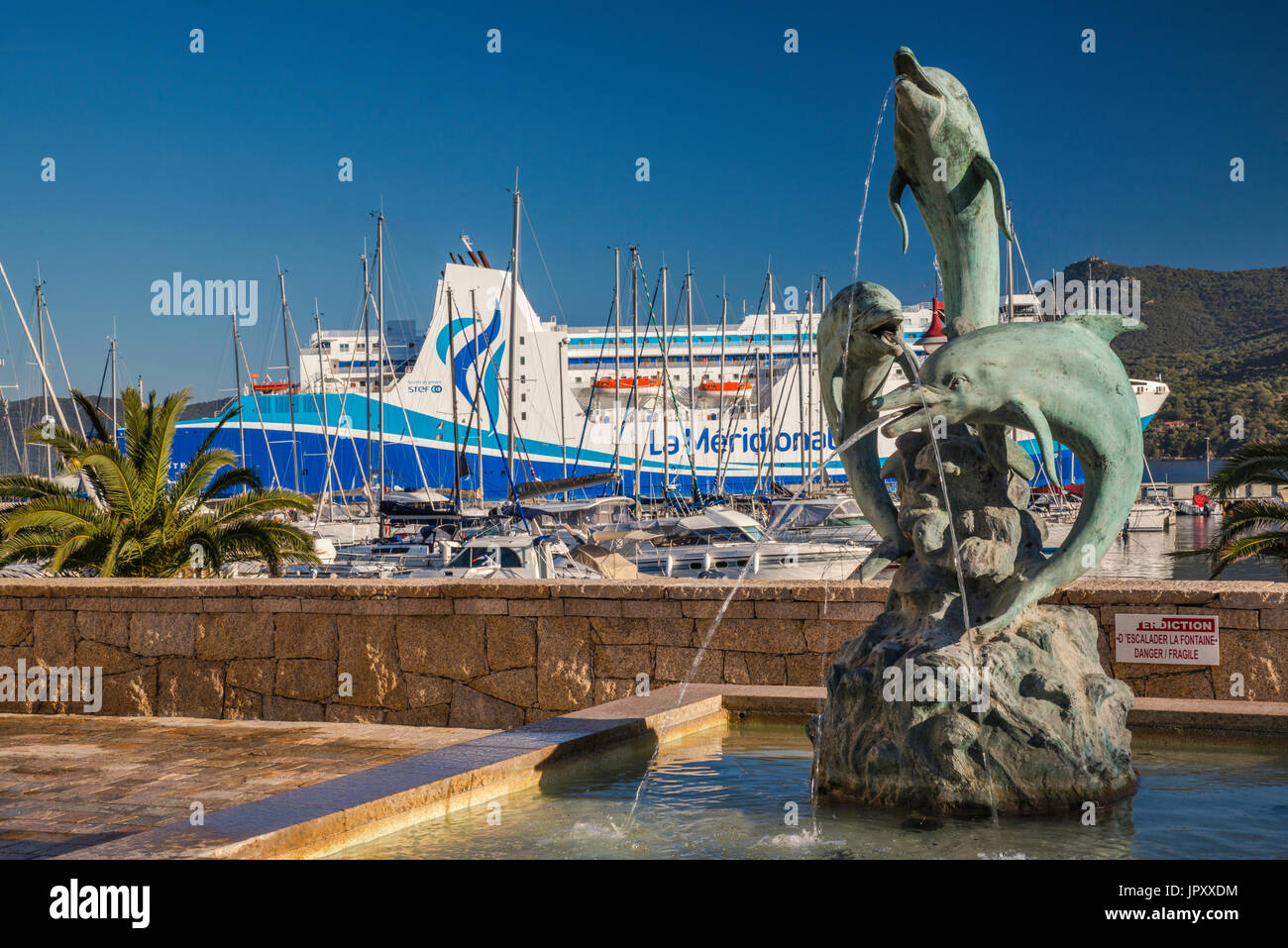 Dolphins fountain at waterfront, sailboats, M/F Kalliste ferry at pier ...