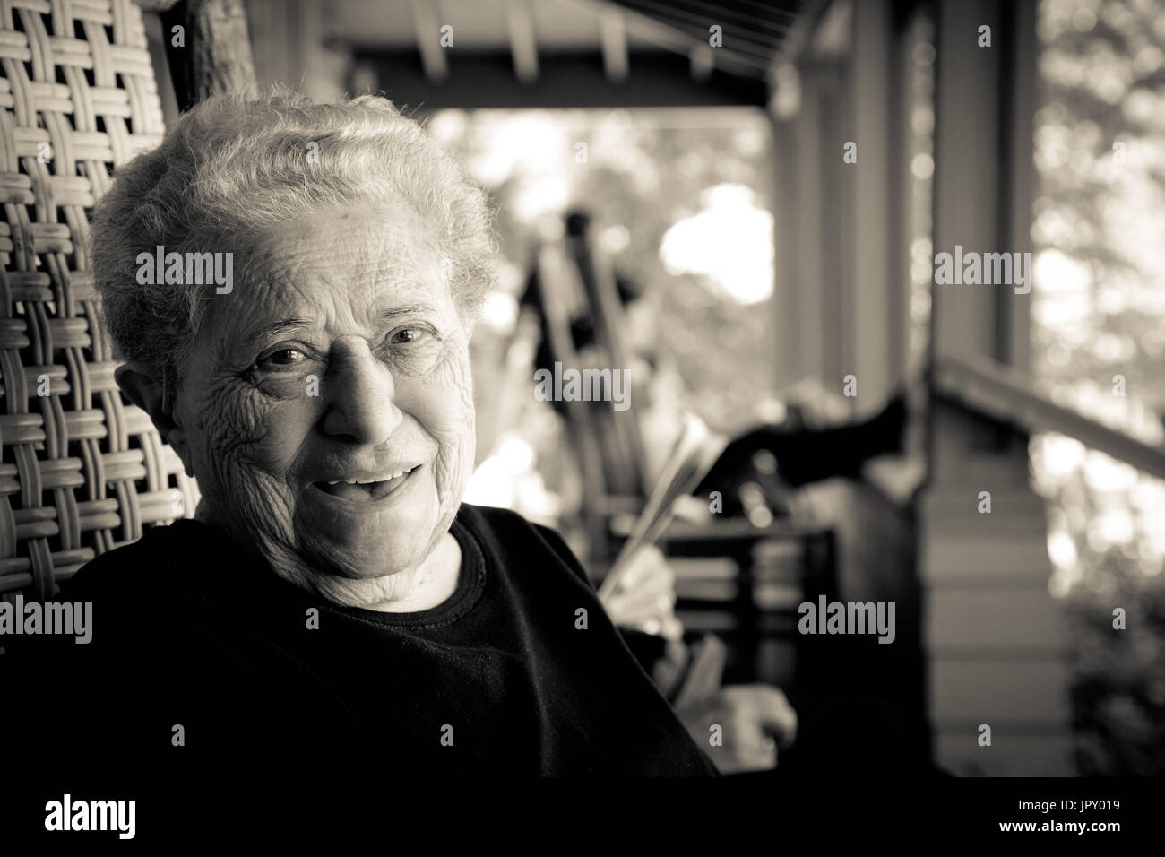 Female senior citizen smiling on porch Stock Photo - Alamy