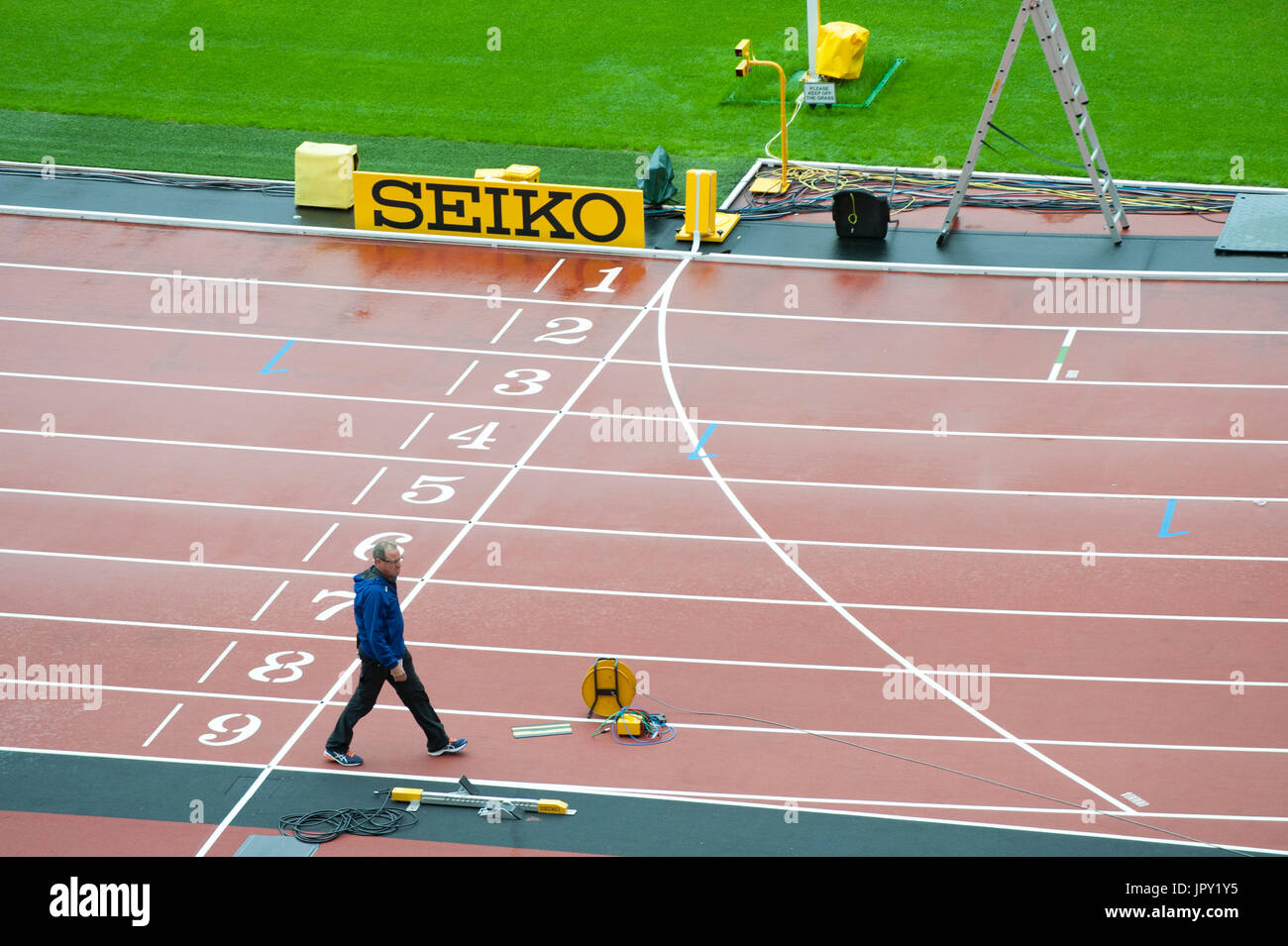 London, UK. 2nd Aug, 2017. A technician walks on the track in the rain ...