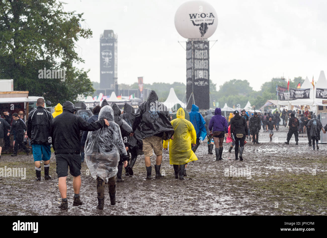 Wacken, Germany. 3rd Aug, 2017. Festival visitors walk across a muddy ...