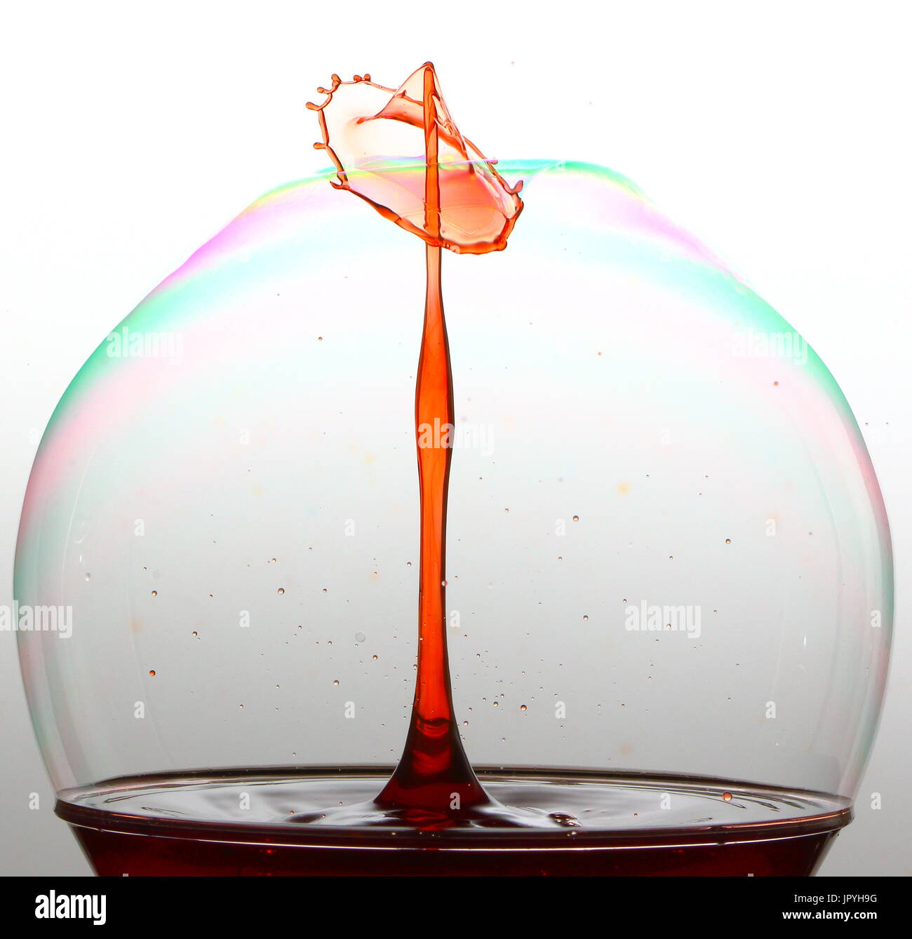 Multi coloured water drop rising from container producing an unusual ...