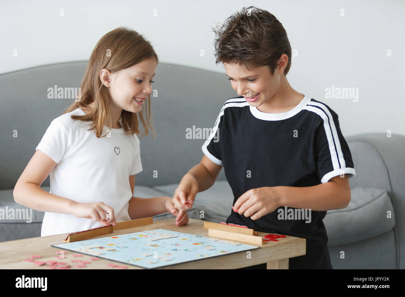 Two children playing board game at a table Stock Photo - Alamy