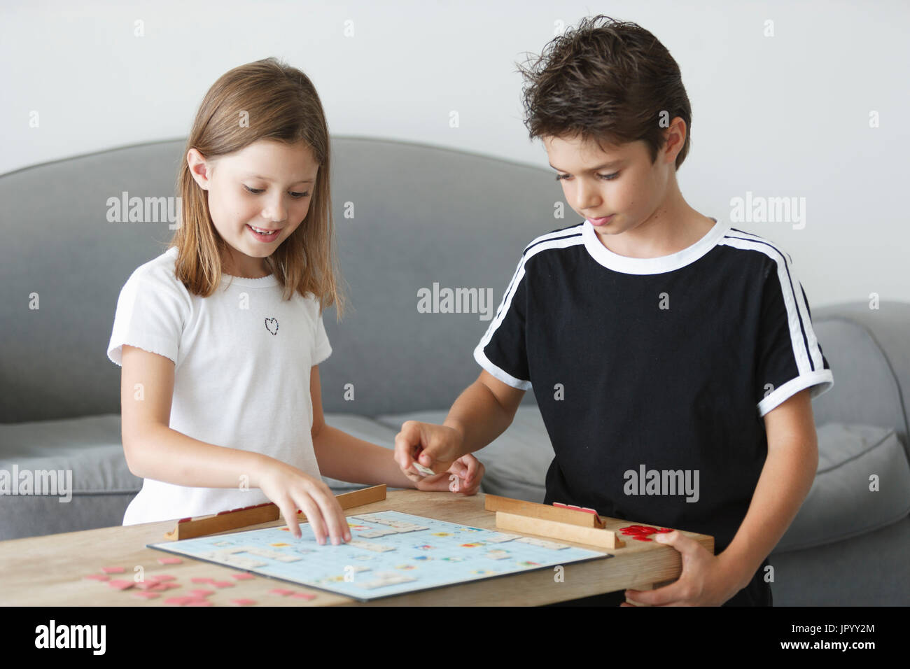 Two children playing board game at a table Stock Photo - Alamy