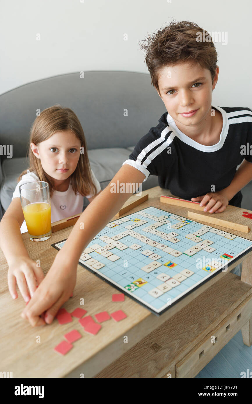 Two children playing board game at a table Stock Photo - Alamy