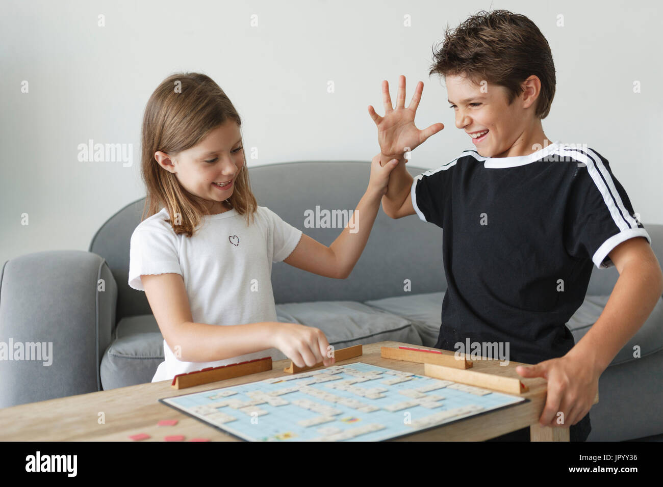 Two children playing board game at a table Stock Photo - Alamy