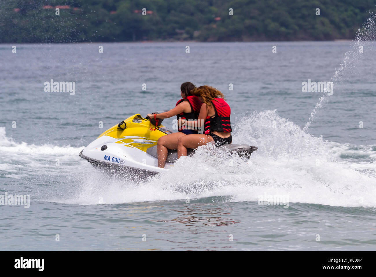 Guanacaste, Costa Rica- July 25: female firiends riding a wave runner ...