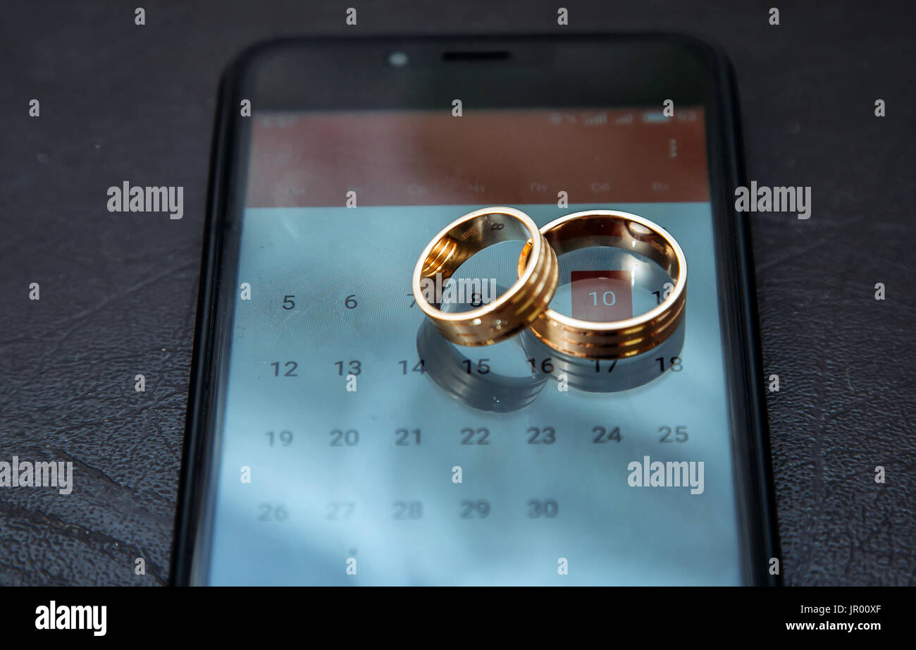 Wedding date with wedding rings on phone Stock Photo - Alamy