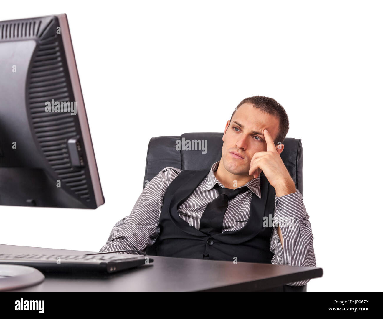 Tired young businessman sitting in front of his computer with a ...