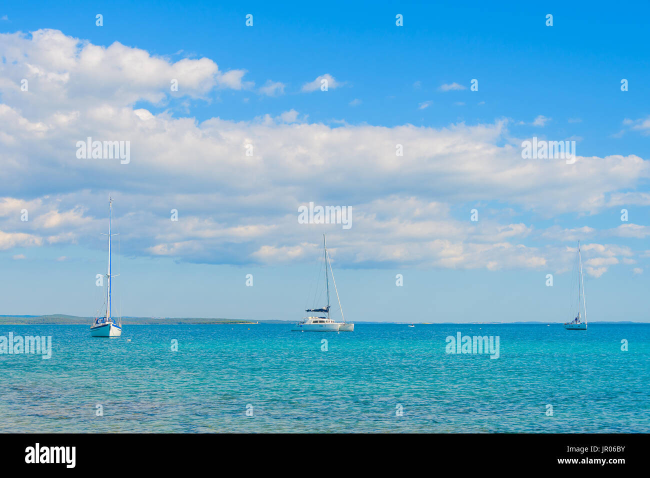 Luxury sailing catamaran and two sailing boats in open sea Stock Photo ...
