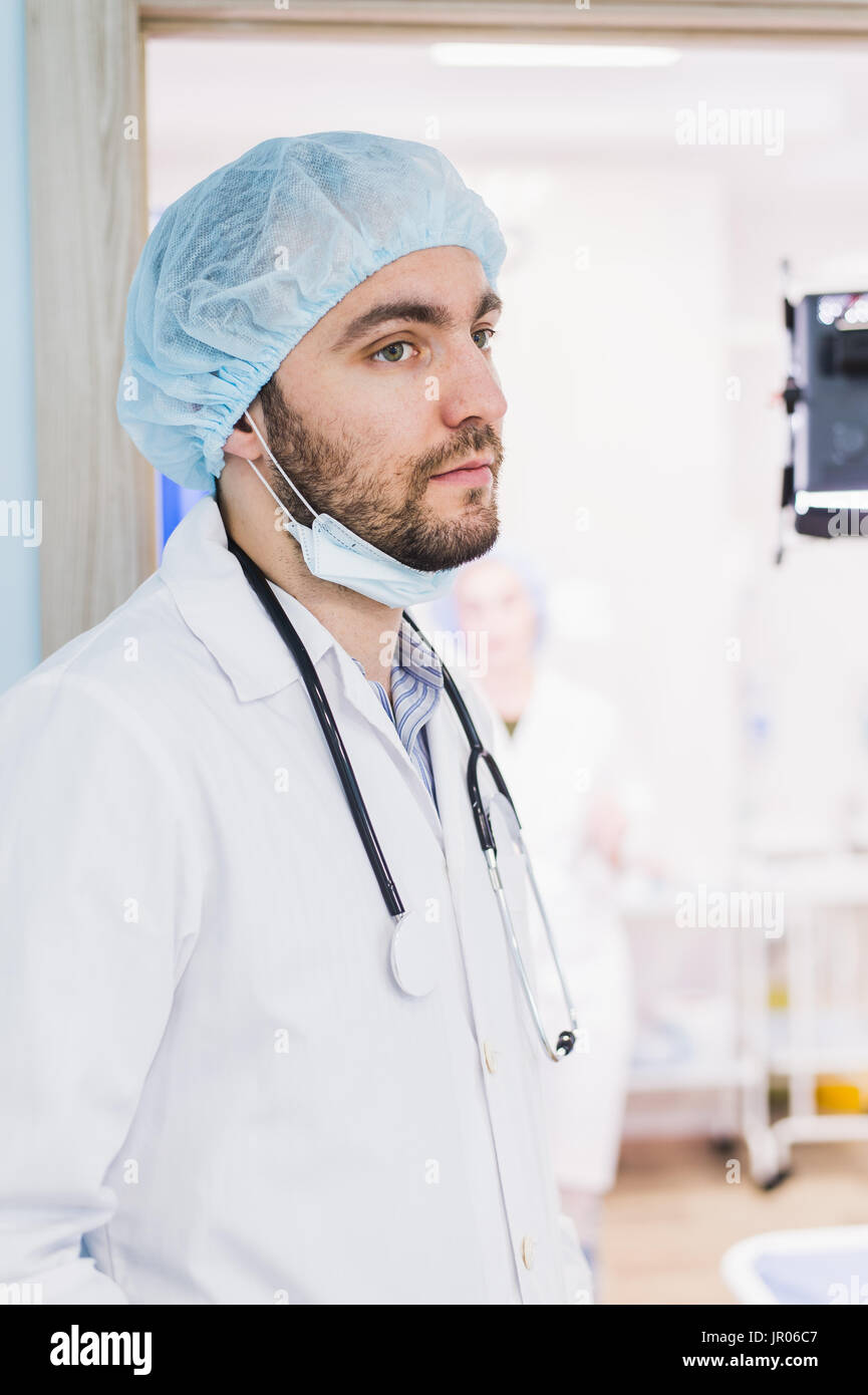 A young handsome pensive man doctor at hospital ward before operation ...