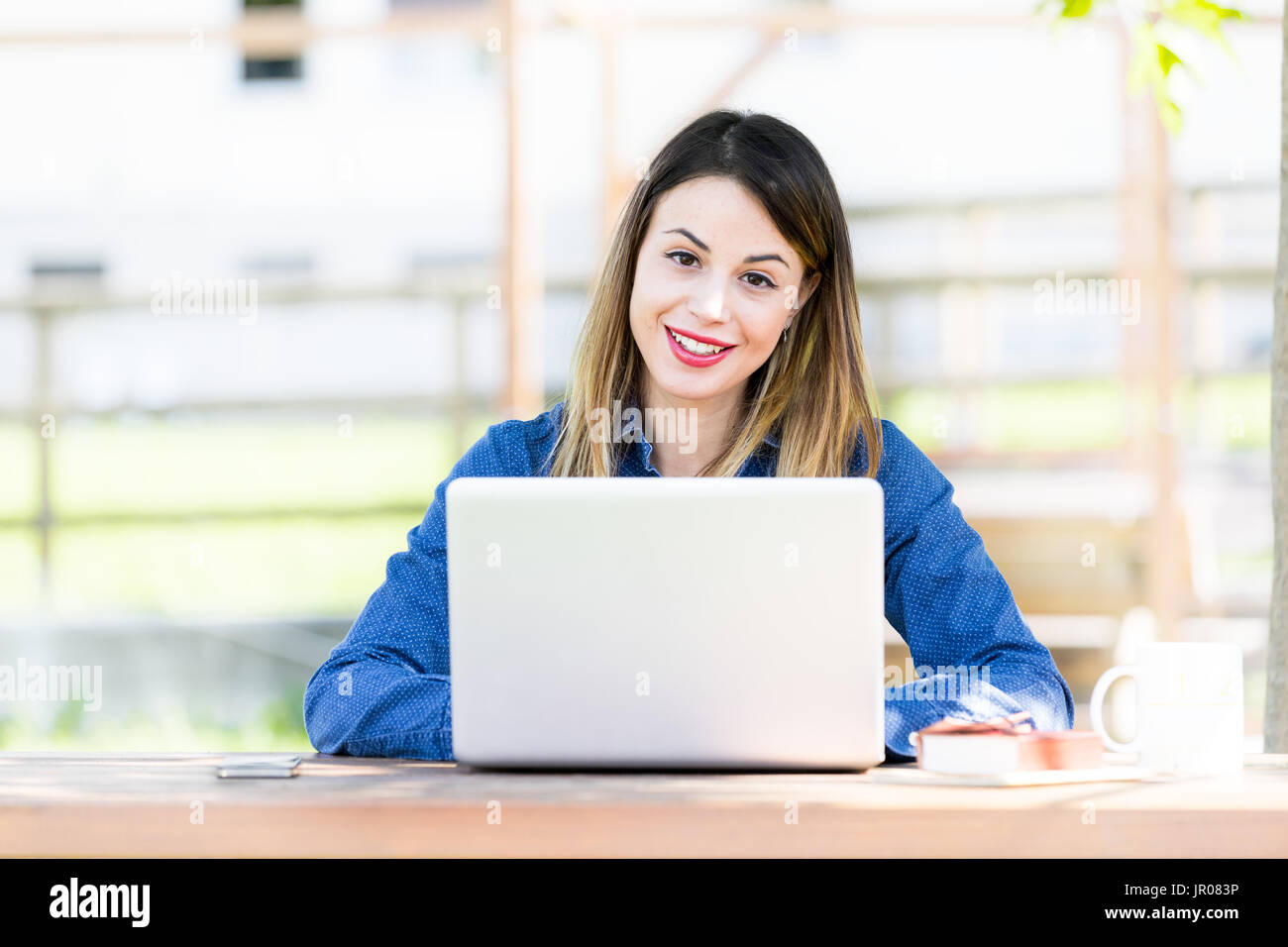 A beautiful young girl smiling and looking towards the camera while ...