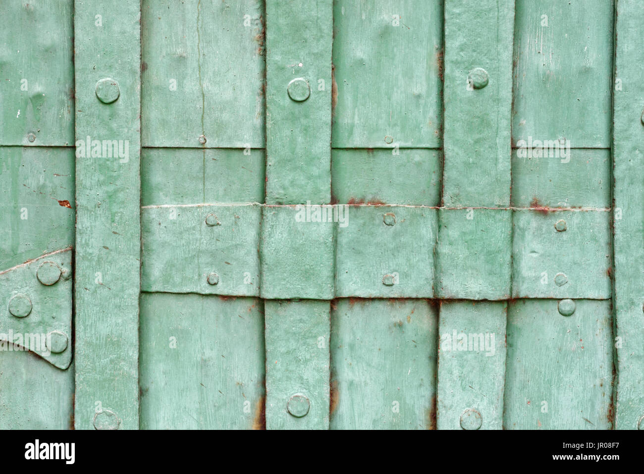 Backgrounds and textures: old green painted riveted metal door close-up ...