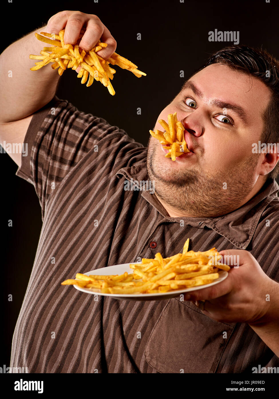 Diet failure of fat man eating french fries fast food. Portrait of ...