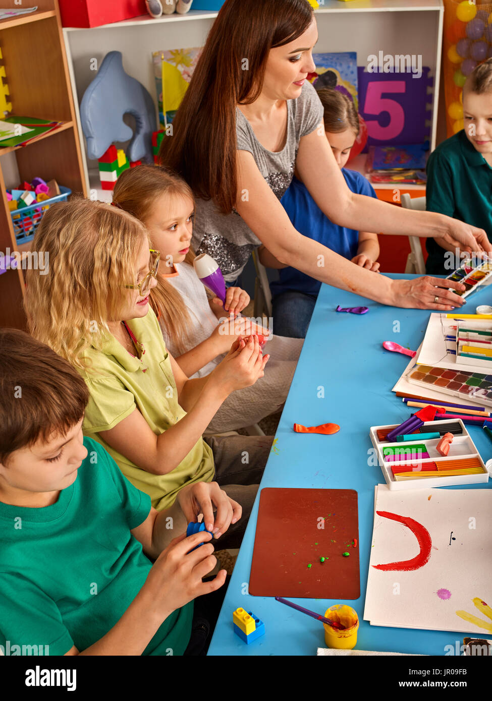 Plasticine modeling clay in children class. Teacher teaches kids ...