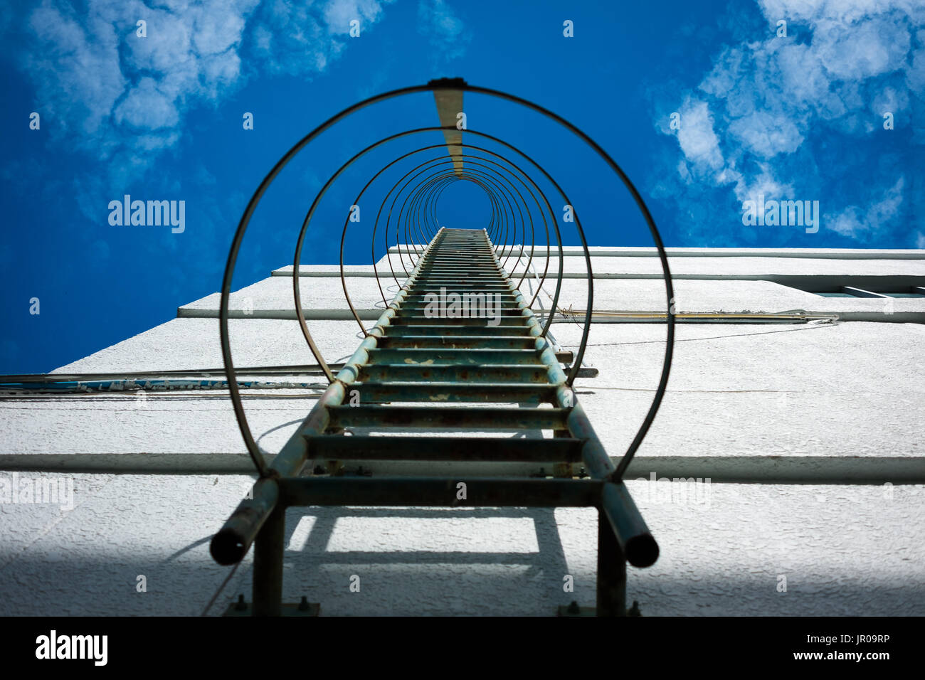 Fire escape metal ladder on a industrial building with blue sky Stock ...
