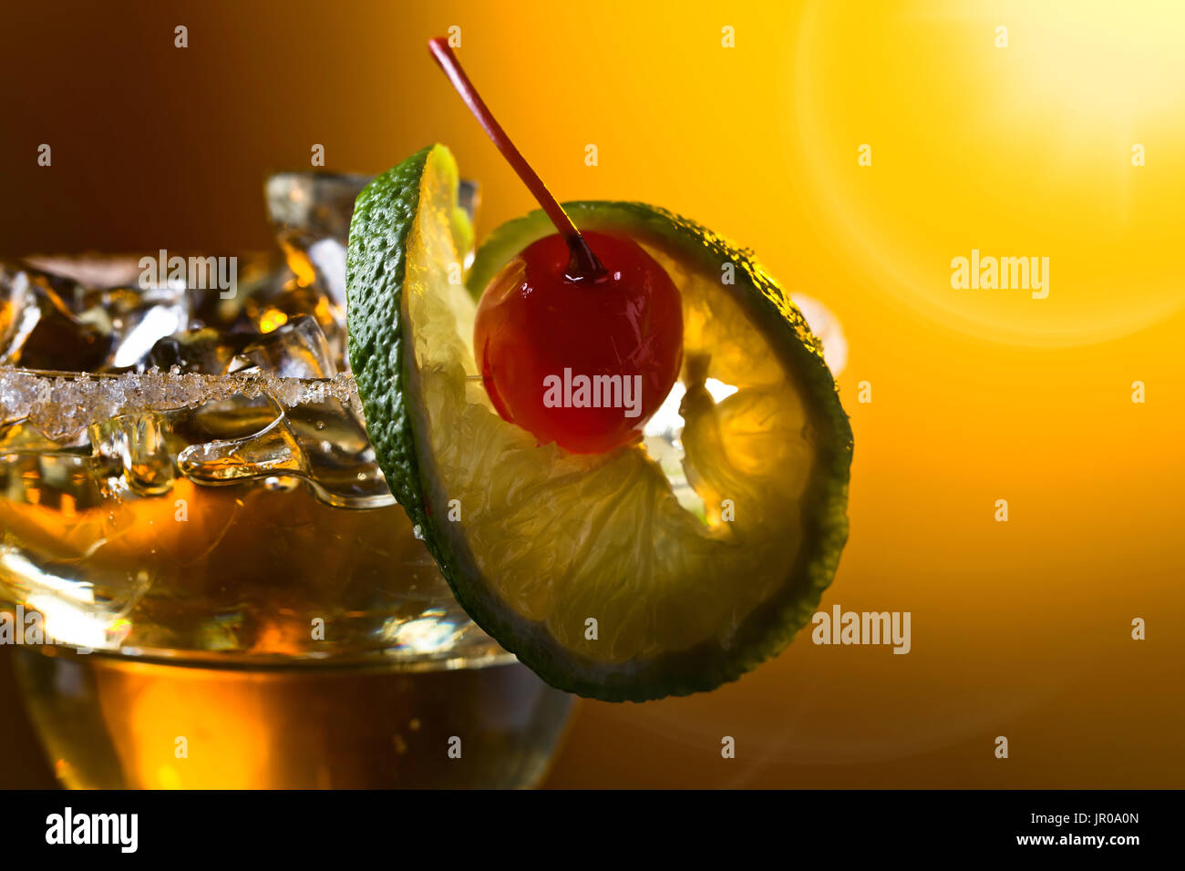 Cold alcoholic cocktail with ice . Cocktail garnished with cherry and ...