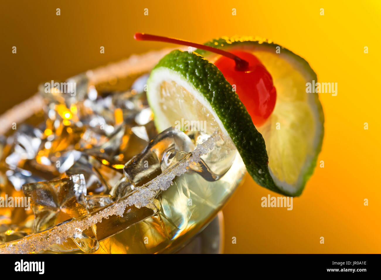 Cold alcoholic cocktail with ice . Cocktail garnished with cherry and ...