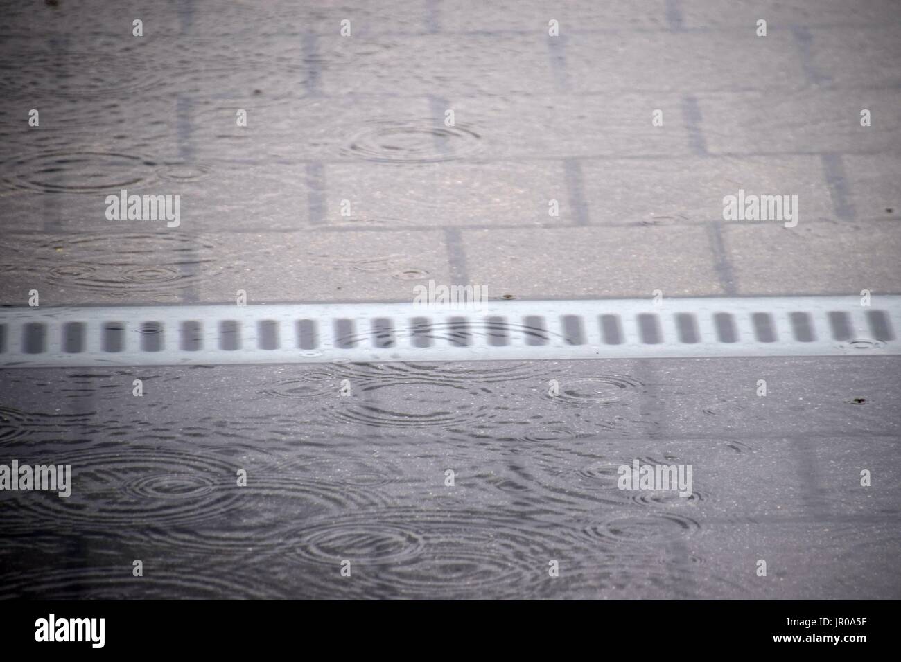 flood waterdrain on a walkway after heavy rain, water on a road ...