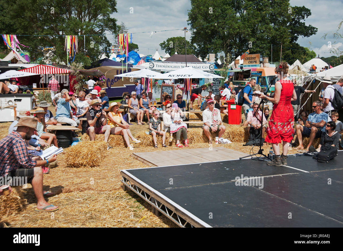Families watch a female singer perform on stage outside at the Port ...