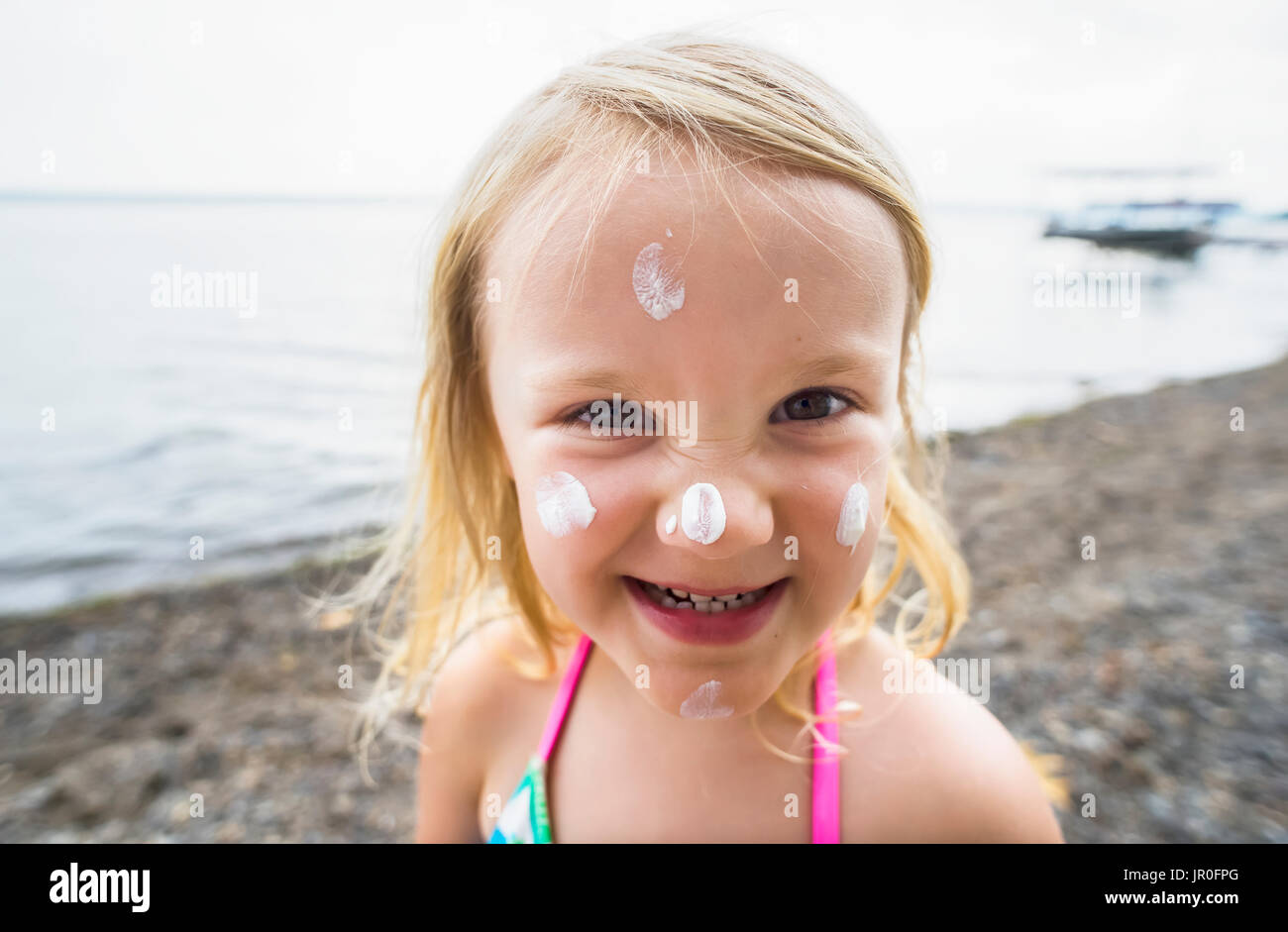 A Young Caucasian Girl With Sunscreen On Her Face Poses For A Picture ...