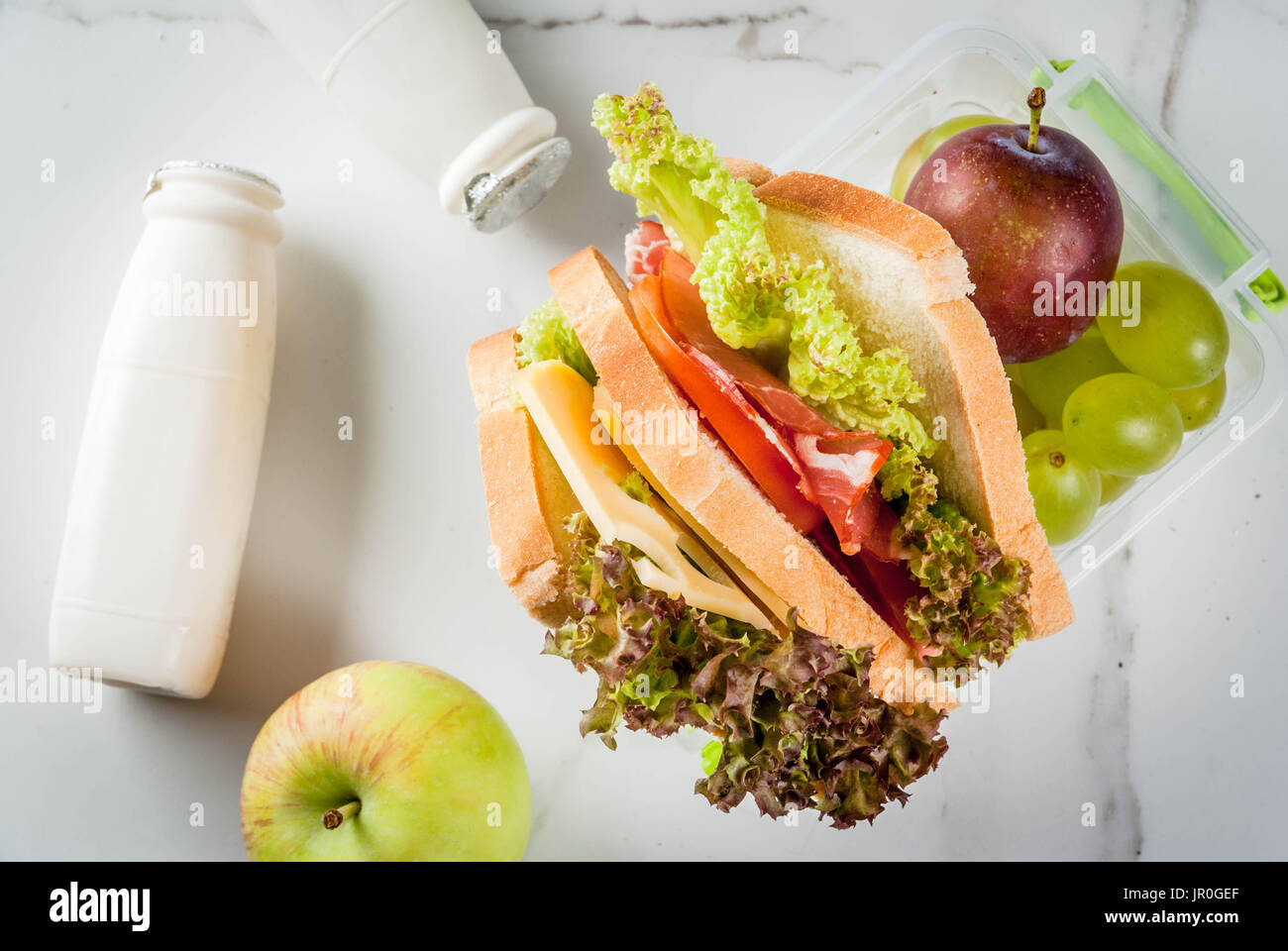 Back to school. A healthy lunch in a box is fresh fruit (apples, plums ...