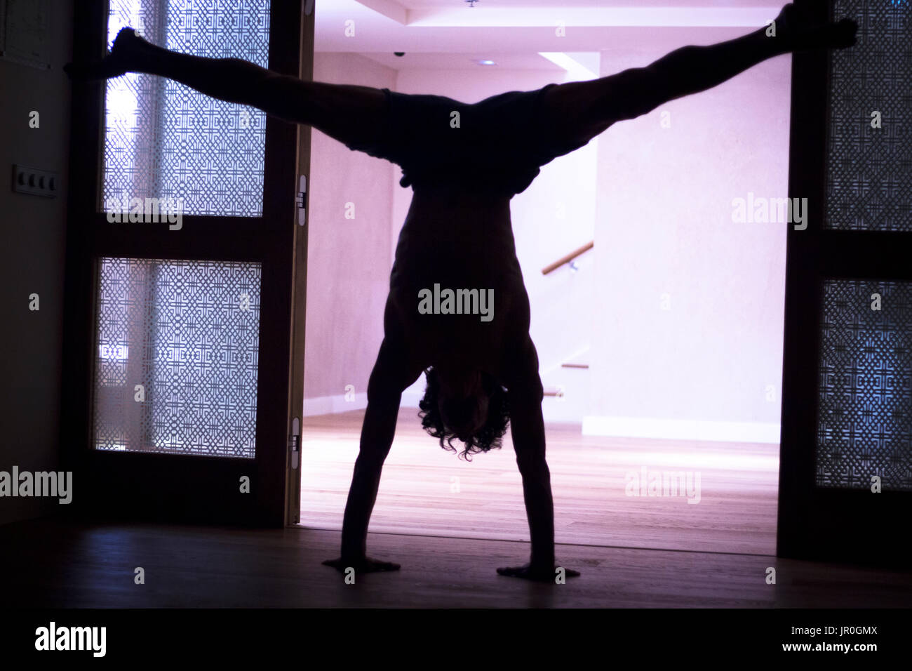 Male yoga teacher doing handstand inversion alisthenics and yoga asana ...