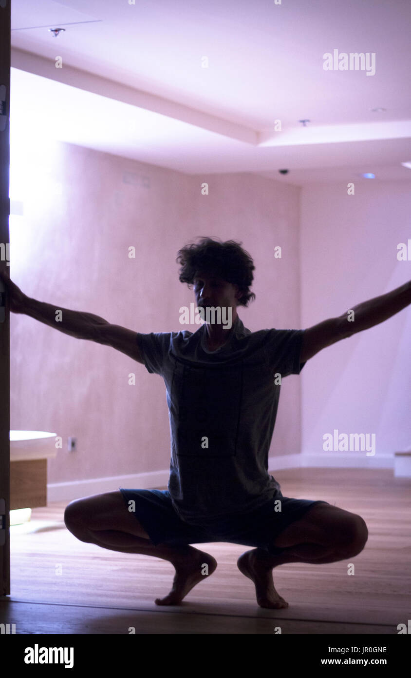 Male yoga teacher doing splits leg stretching flexibility calisthenics ...