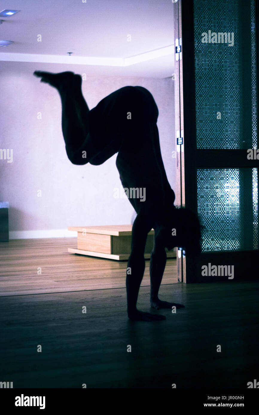 Male yoga teacher doing handstand inversion alisthenics and yoga asana ...