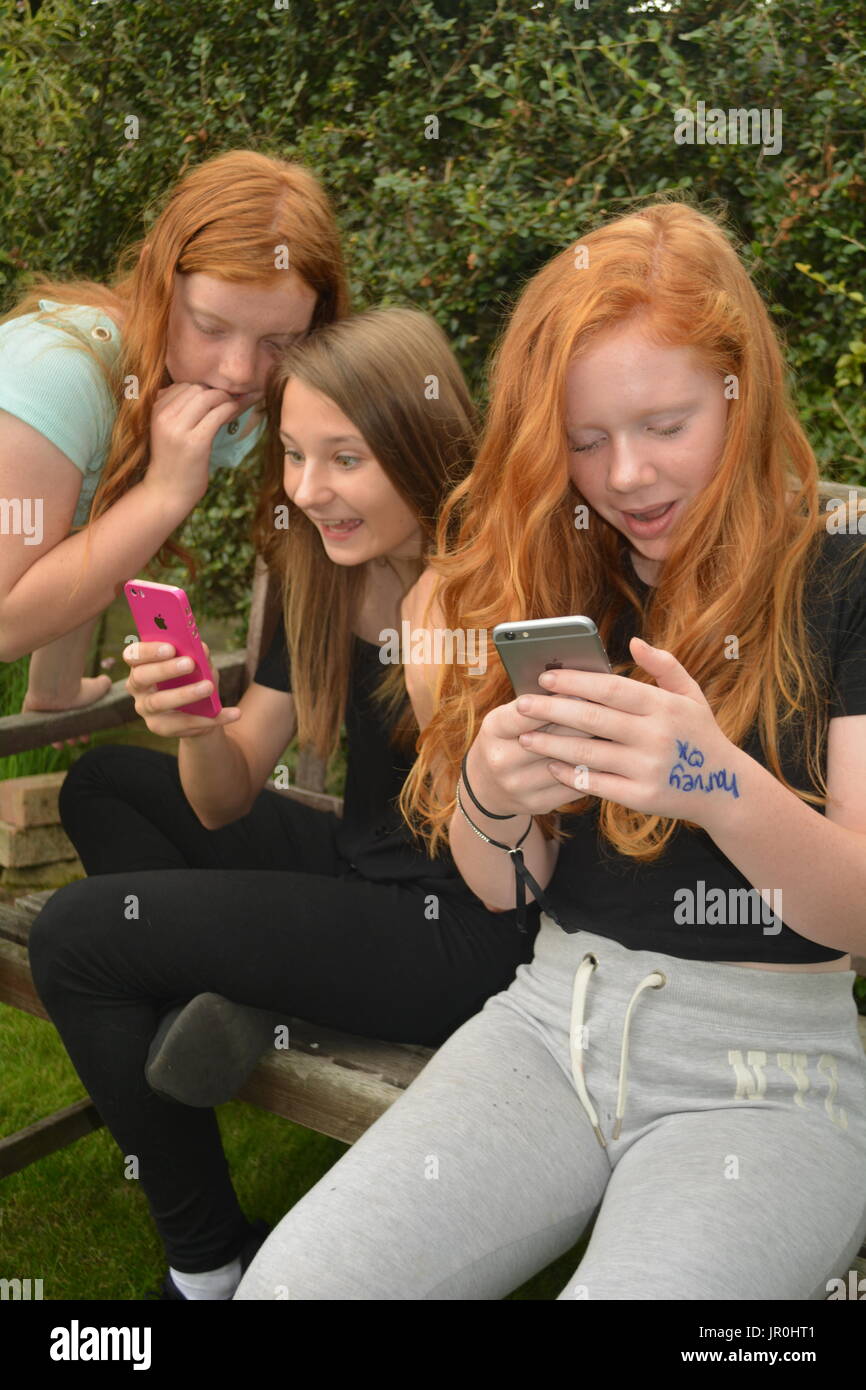 Girls messing about on mobile phones Stock Photo - Alamy