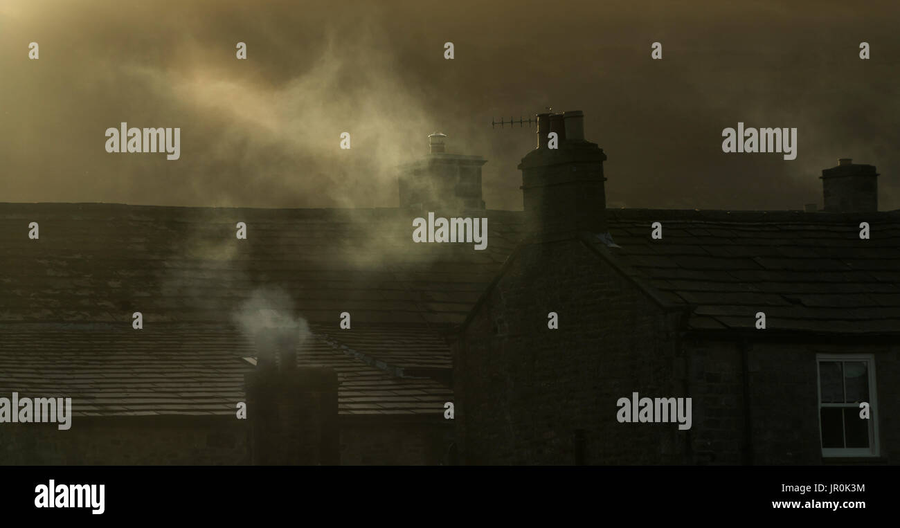 Smoke From Chimneys On A Rooftop Floats Into The Air; Reeth, Yorkshire ...