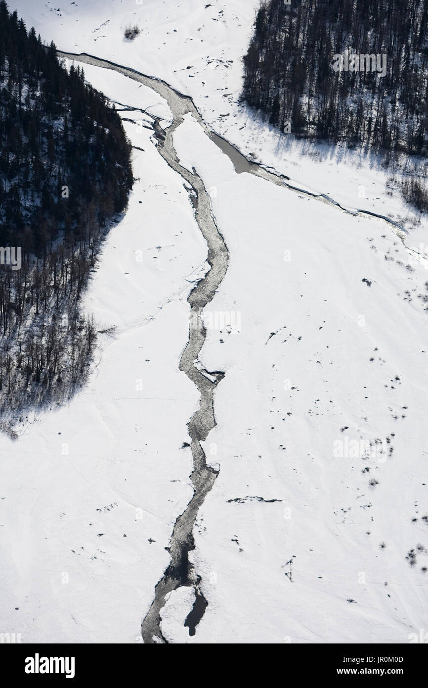 Aerial View Of A River Running Through Snow In The Kenai Mountains In ...