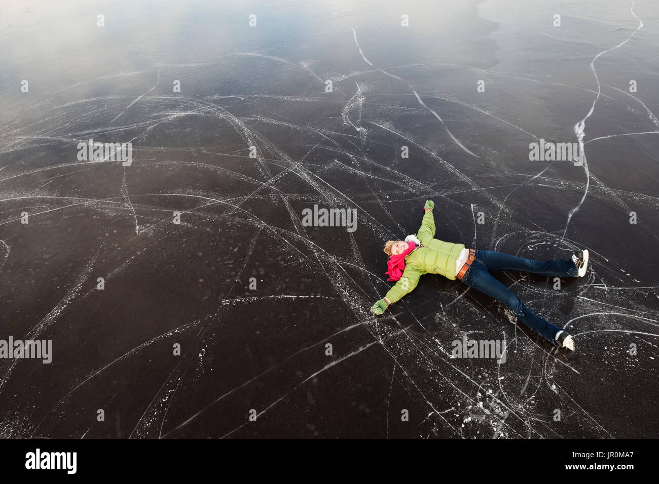 A Young Woman Lays On Her Back On A Frozen Surface Looking Up While Ice ...