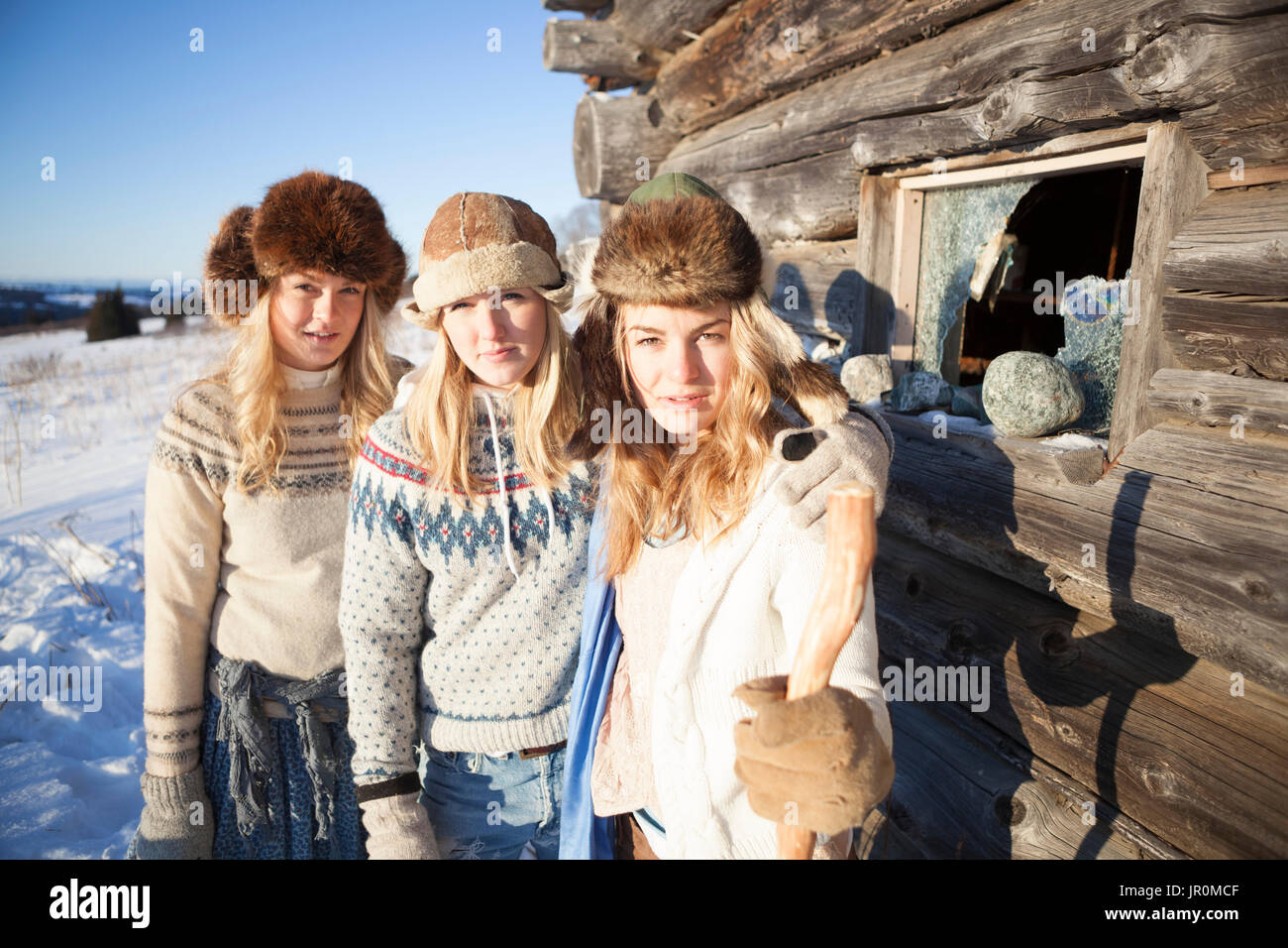 Portrait Of Three Girls Standing By A Log Cabin Wearing Fur Hats; Homer ...