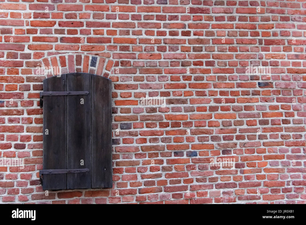 Window in an old red brick wall closed with wooden shutter Stock Photo ...