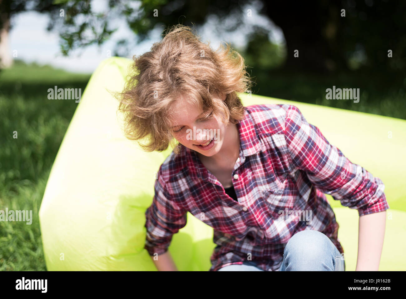 Teenage girl sitting down on an inflatable outdoors Stock Photo - Alamy