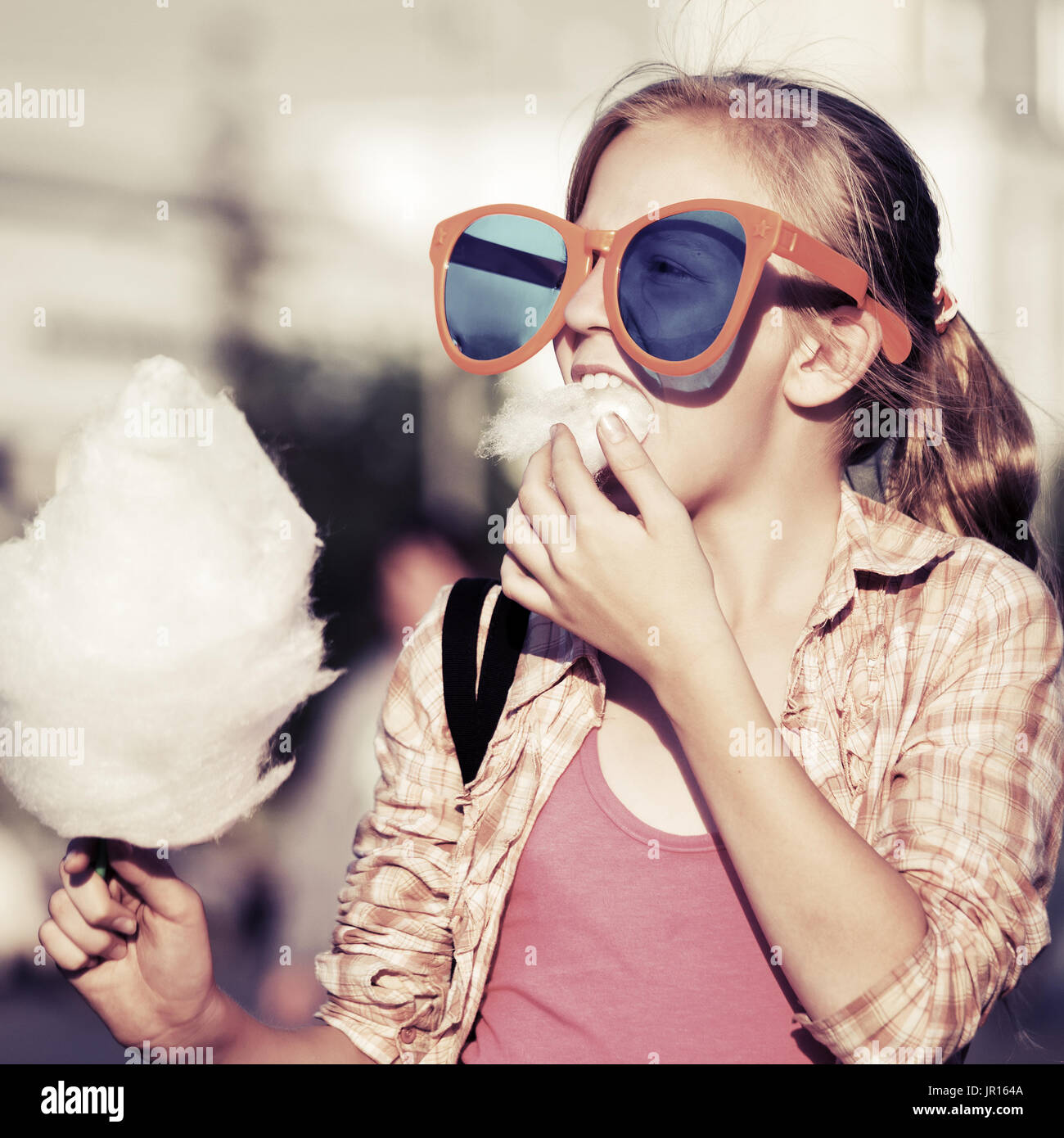 Happy teen girl eating cotton candy on a city street Stock Photo - Alamy