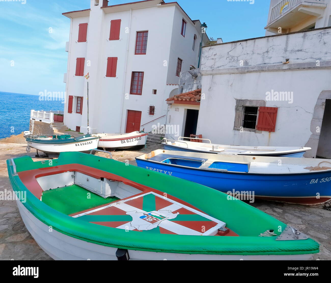 Smal boat painted in the colors of the Basque flag in the small fishing ...