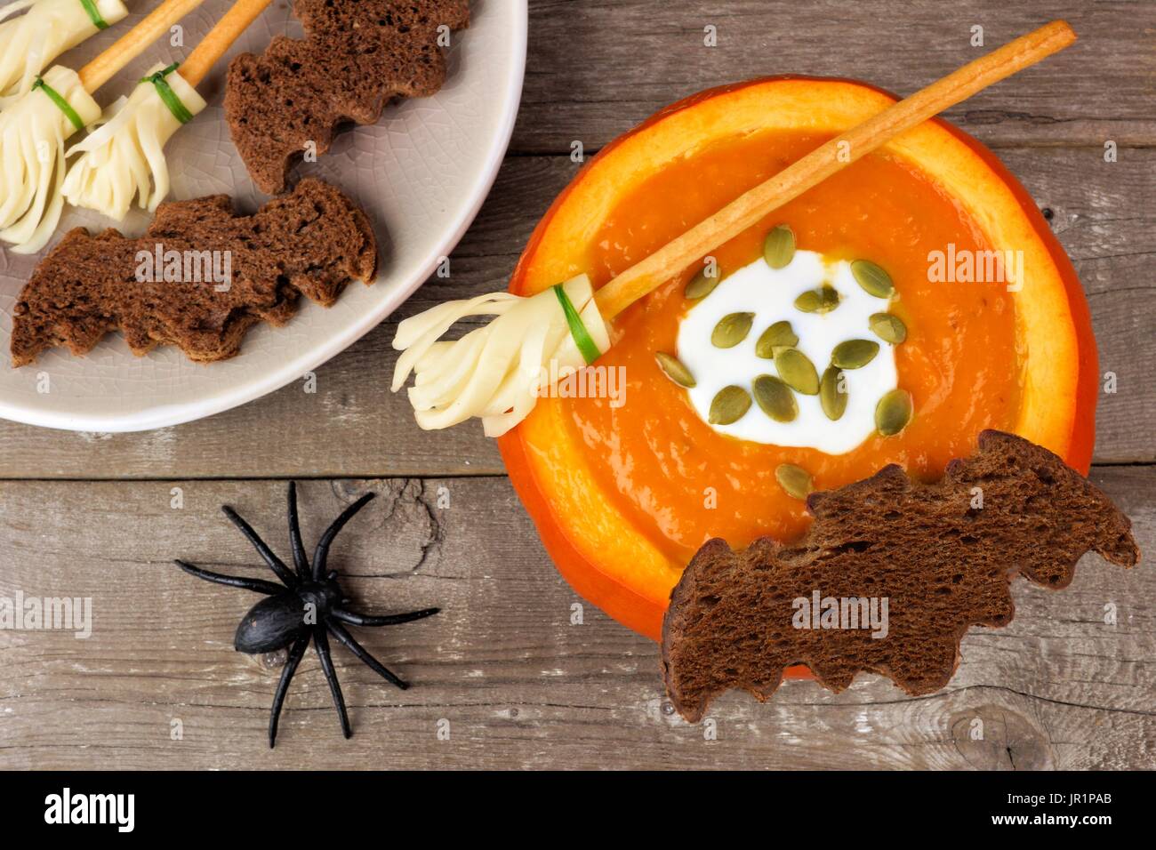 Halloween pumpkin soup with witch's broom and bat bread snacks on a ...