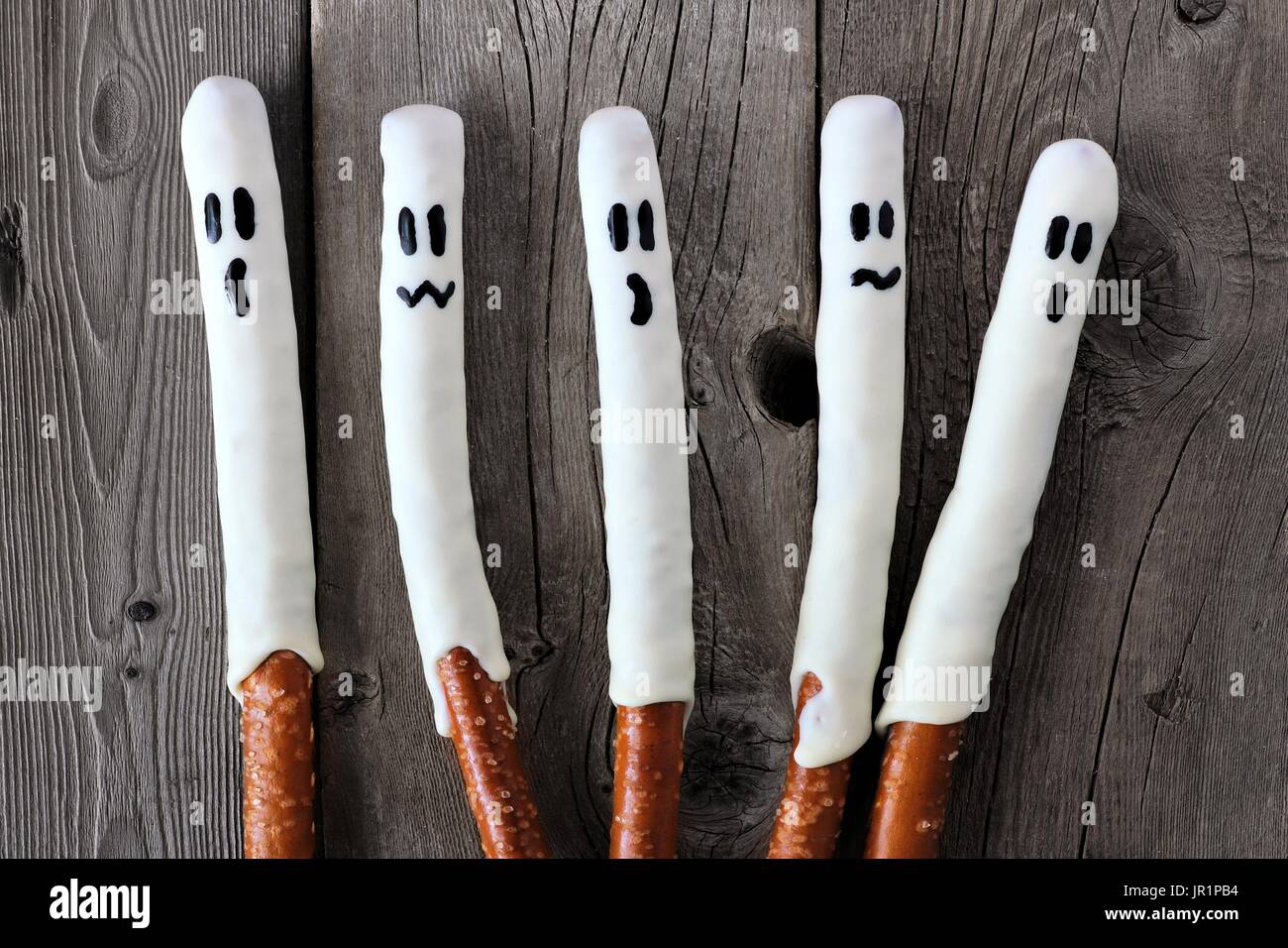 Group of Halloween ghost, candy dipped pretzel rods on aged wood ...
