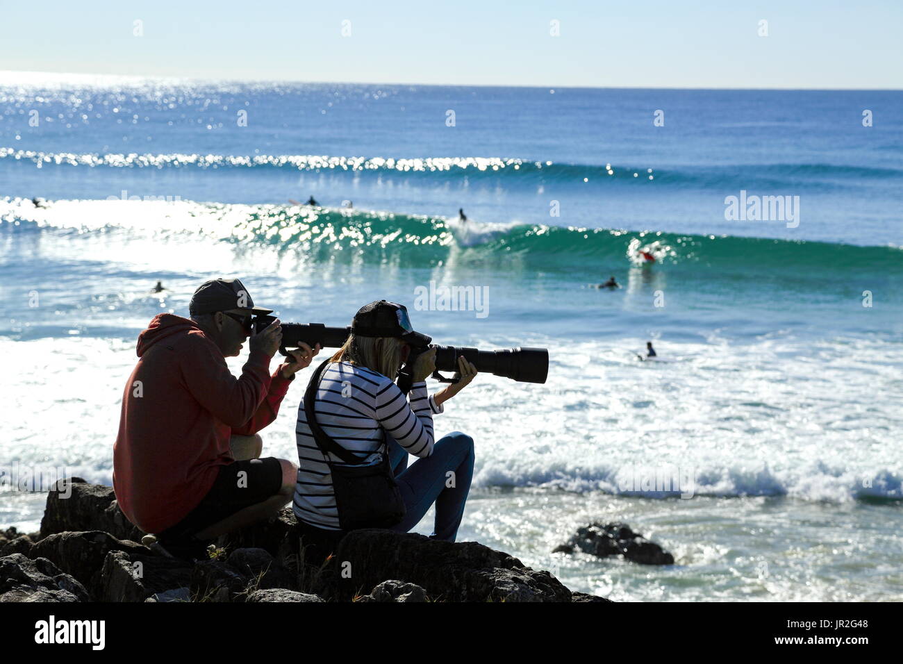Male and female photographers photographing surf and surfers Stock ...