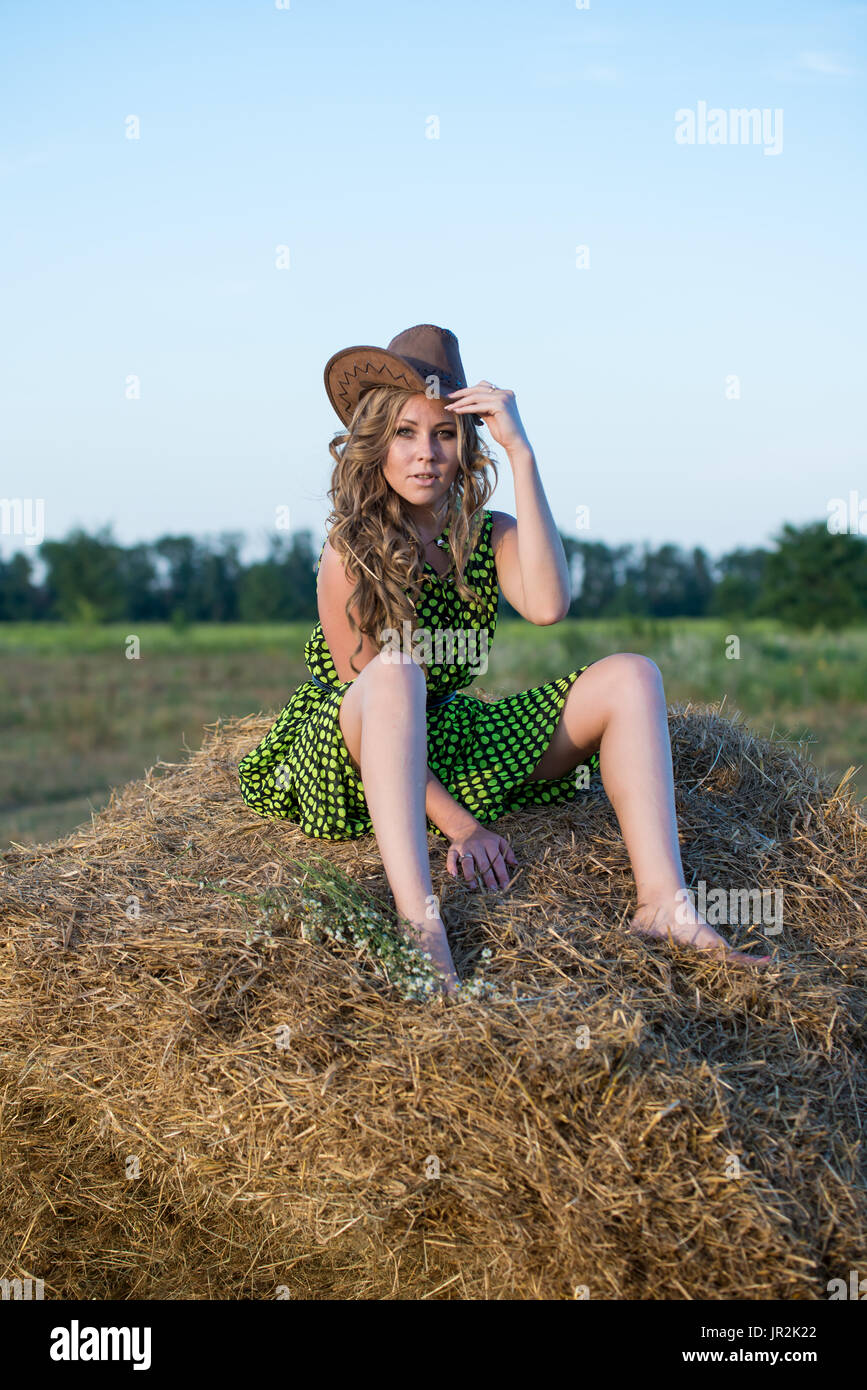 Pretty young girl on a haystack Stock Photo - Alamy