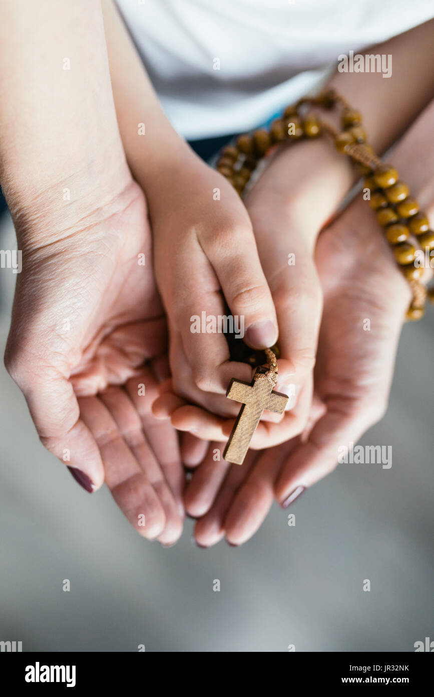 Family prayer. Mother and child hands with wooden rosary Stock Photo ...