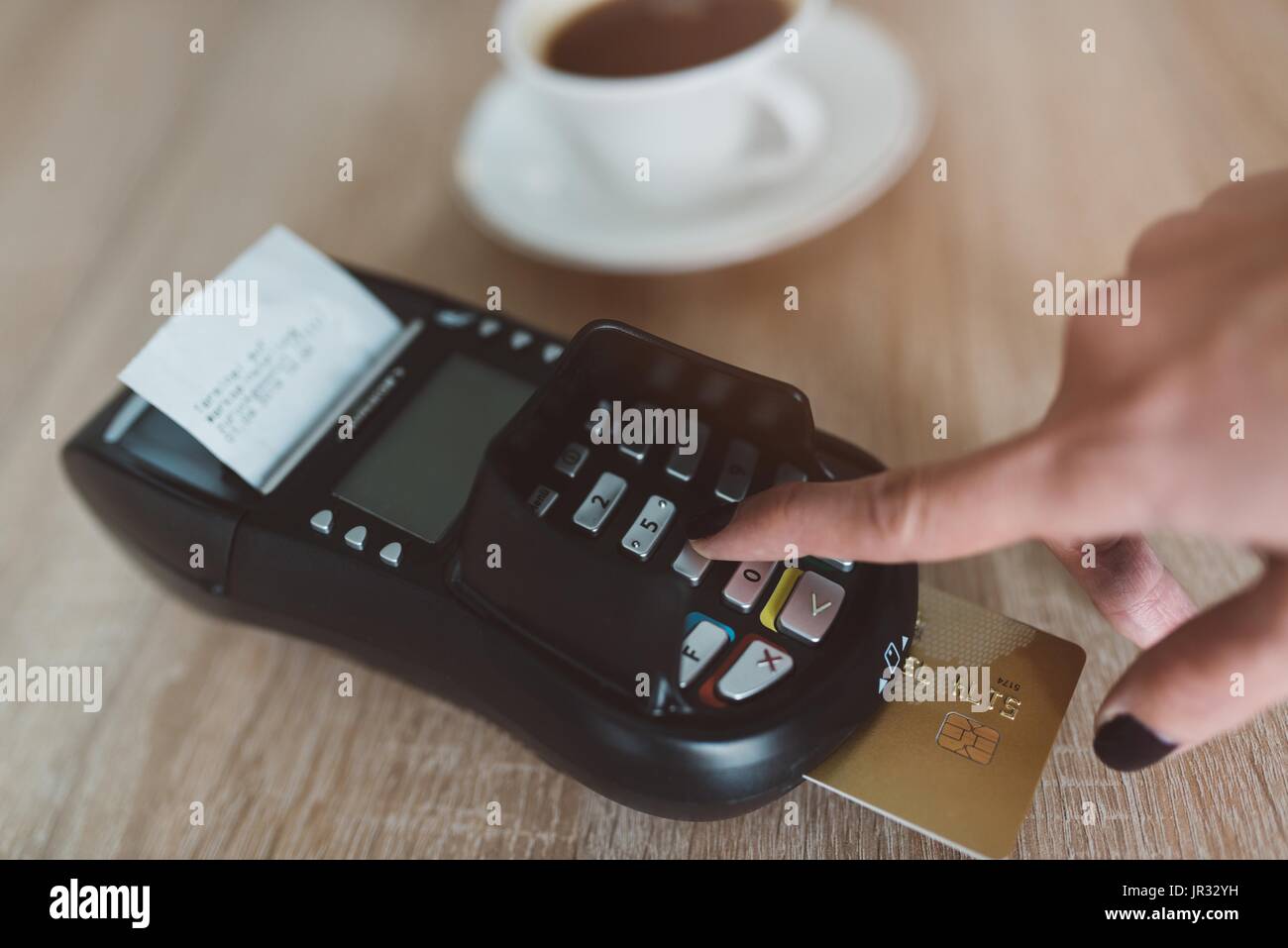 Consument entering pin code on card terminal during payment Stock Photo ...